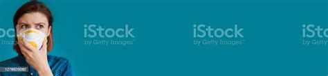 얼굴에 의료 마스크를 가진 백인 여성은 걱정하고 스튜디오 벽에 뭔가를 광고 파란색 여유 공간을보고있다 성인에 대한 스톡 사진 및 기타 이미지 Istock