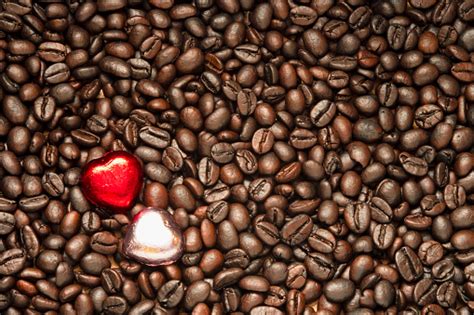 커피 콩 벽지 클로즈업 다크 브라운 로스팅 커피 콩 배경 장식 사랑스러운 미니 하트 모양의 초콜릿 레드와 핑크 컬러 발렌타인 데이 축하 아이디어 개념 갈색에 대한 스톡 사진