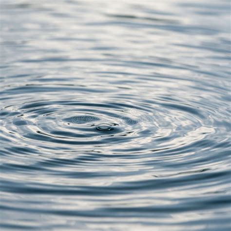 Concentric Ripples Spread Across A Calm Water Surface Originating From A Central Stock