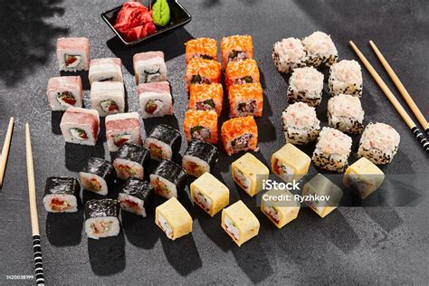 어두운 배경에 설정 된 마키 초밥 다양한 롤이 있는 큰 마키 세트 초밥 롤과 호소마키의 구성 블랙 배경 잎 하드 섀도우가 있는 스타일 컨셉 초밥 메뉴 0명에 대한 스톡 사진
