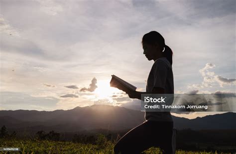 일몰 배경에서 산에서 성경으로 신에게 기도하는 여자의 실루엣 예배에 손을 들고 있는 여자 기독교 종교 개념입니다 25 29세에 대한 스톡 사진 및 기타 이미지 Istock