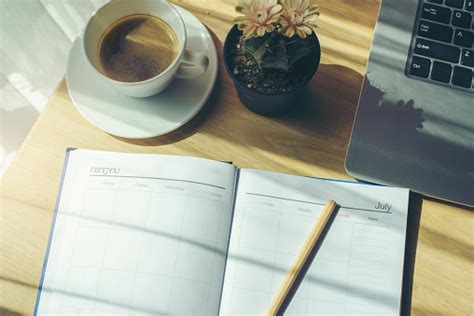 주최자가 사무실 책상에서 시간표 일일 약속 및 관리 작업을 계획하기위한 일기 플래너는 캘린더 북에서 회의 의제를 작성하고 집에서 온라인으로 작업합니다 플래너 북과 2022