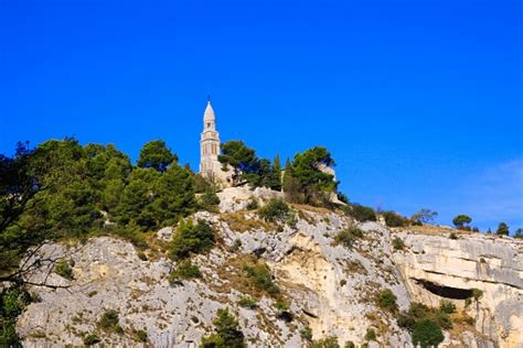 푸른 하늘에 대한 소나무와 사이프러스 나무와 산 봉우리에 고립 된 로마 가톨릭 교회에 낮은 각도보기 계획 D́orgon 부쉐 뒤