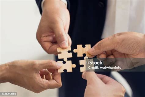 팀워크와 파트너십의 개념 사무실에서 퍼즐 조각을 맞추는 사업가의 손과 직소 퍼즐 팀으로 모입니다 자선 자원 봉사자 팀으로서의 비즈니스 단결 퍼즐에 대한 스톡 사진 및 기타