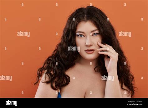 A Stunning Plus Size Woman With Striking Makeup Poses Gracefully