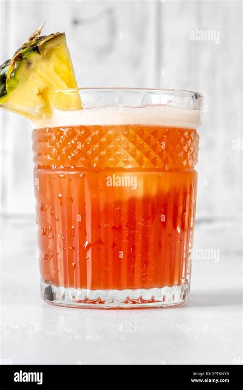 Glass Of Jungle Bird Cocktail Garnished With Pineapple Wedge Stock