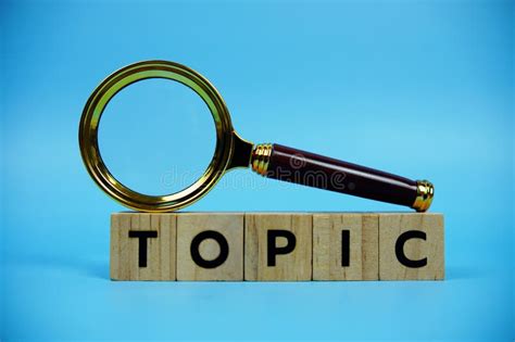 Topic With Wooden Blocks Alphabet Letters And Magnifying Glass On Blue Background Stock Image
