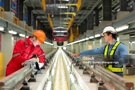 전기 열차가 전기 열차 수리점에 주차 된 후 전기 열차 엔지니어 및 기술자는 도구를 사용하여 검사 라운드에 따라 철도 및 전기 열차를 검사합니다 철도에 대한 스톡 사진 및