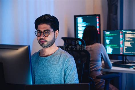 Asian Software Developers Working On Multiple Screens Displaying Code