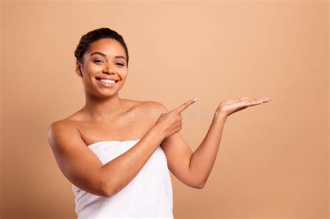 Photo Of Gorgeous Cheerful Woman Point Hold Empty Space Naked Shoulders Isolated On Beige Pastel