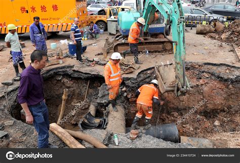 Chinese Workers Repair Broken Water Pipeline Causing Road Collapse Road