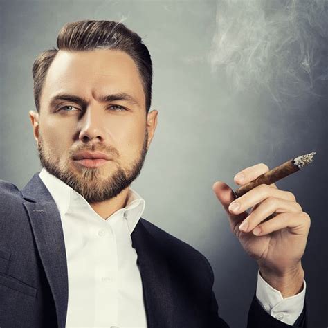 یک مرد کسب و کار خوش تیپ با استفاده از یک سیگار در حالی که یک دست در
