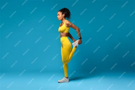 Premium Photo Fitness Woman Doing A Quad Stretch On Blue Background