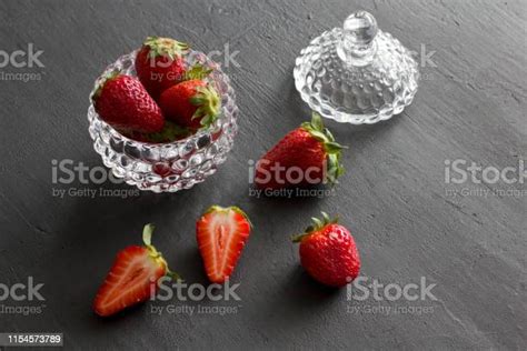 유리 둥근 그릇에 아름 다운 붉은 딸기 검은 어두운 콘크리트 배경에 딸기 소박한 스타일 수평 Minimalism 절반 딸기를 잘라 맨 위 뷰 텍스트의 공간 복사 0명에 대한