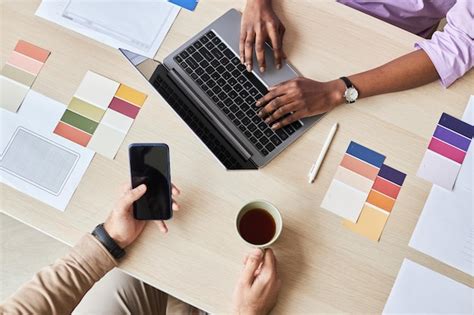 Premium Photo Top View Closeup Of Two Designers Using Laptop Working On Ui Project In Office
