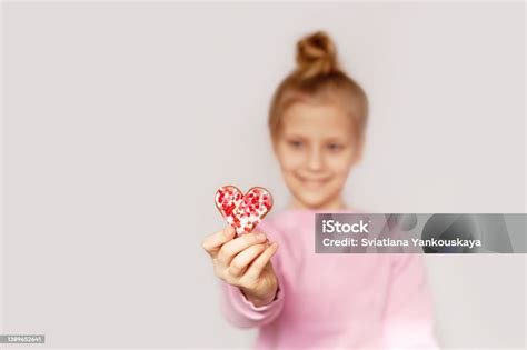 쾌활한 소녀는 진저 브레드를 마음 모양으로 들고 있습니다 밝은 배경과 텍스트를위한 공간에 쿠키가있는 소녀의 귀여운 초상화 아이에 대한 스톡 사진 및 기타 이미지 Istock