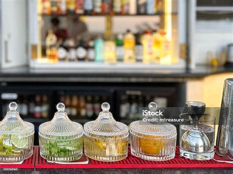 길고 빨간 고무 칵테일 바 카운터에 바 러너 매트 금속 더블 지거 측정 칵테일 셰이커 공개 바 배경 전경에 초점에 준비된 칵테일 음료 장식 재료를 덮는 화려한 유리