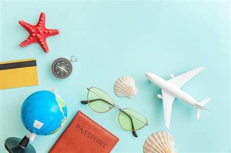 파란색 파스텔 화려한 배경에 비행기 여권 선글라스 글로브 골드 신용 카드 및 셸 프리미엄 사진