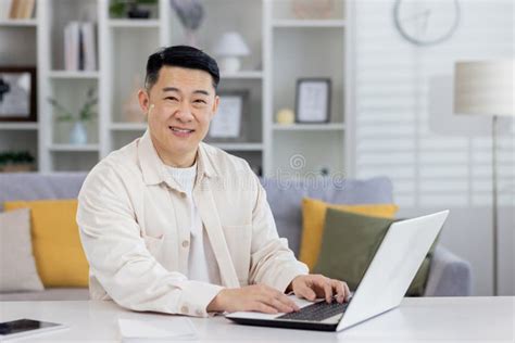 portrait of successful asian programmer man working remotely from home office businessman