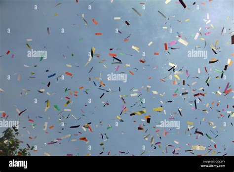 Ticker Tape Being Released At An Event With A Blue Sky Background And Flare From The Sun In The