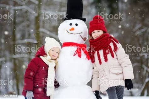두 사랑 스러운 작은 소녀 아름 다운 겨울 공원에서 함께 눈사람을 구축 귀여운 자매는 눈 속에서 재생입니다 2명에 대한 스톡 사진 및 기타 이미지 Istock