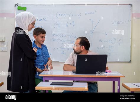 Mother Having Conversation With The Teacher In School About Here Son