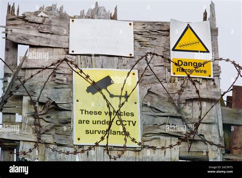 Razor Wire Warning Sign On Security Fence At Construction Site Stock