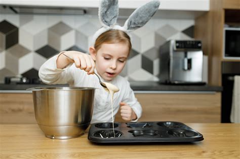 어린 소녀 토끼 귀에 아이가 집에서 부엌에서 쿠키를 굽기 위해 반죽을 곰팡이에 조심스럽게 붓는다 4 5세에 대한 스톡 사진 및 기타 이미지 Istock