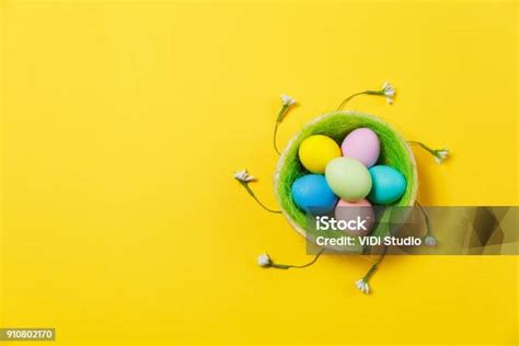 다채로운 파스텔 그린된 부활절 달걀 바구니 흰색 녹색 잔디와 꽃 백합 계곡의 노란색 배경에 고립 광고에 대 한 공간을 복사 합니다 와 텍스트에 대 한 장소 계란에 최고 볼
