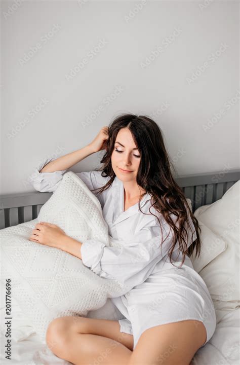 Sexy Young Brunette Woman Wearing A White Shirt On The Bed At Home