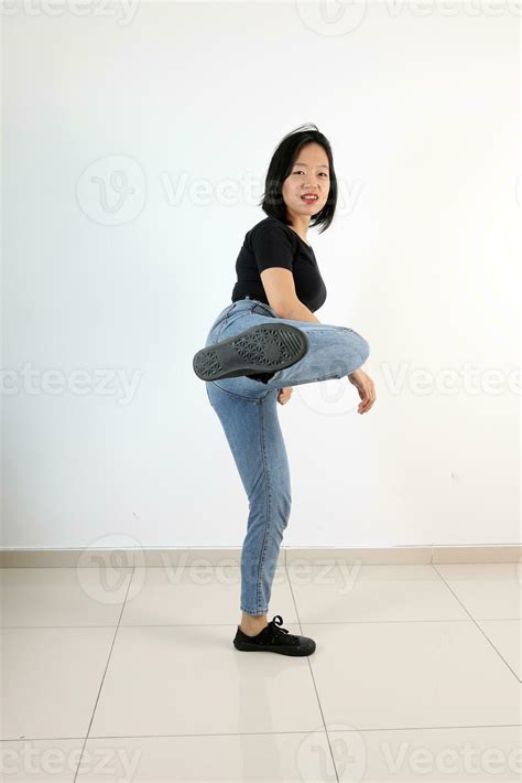 Young attractive south east asian woman pose face expression emotion on white background kick ...