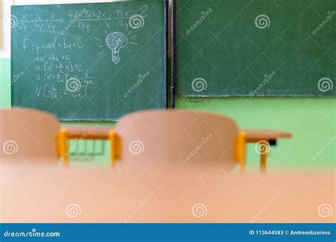 Empty Mathematics Classroom With School Desks Chairs And Blackboard