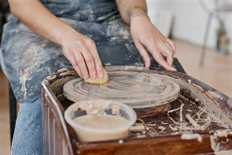 Hands Of Young Woman Wiping Pottery Wheel With Wet Sponge After Creating New Earthenware Items