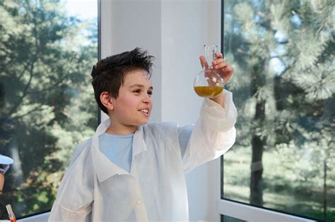 똑똑한 아이 화학 물질이 담긴 플라스크를 들고 화학 교실에서 실험을 수행하는 학교 소년 화학자 과학자 Stem 주제에 대한 스톡