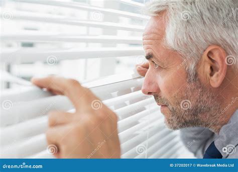 Hombre De Negocios Maduro Serio Que Mira A Escondidas En Oficina Imagen De Archivo Imagen De