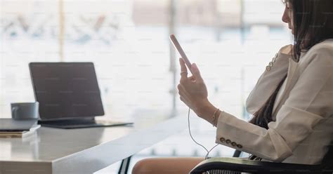 휴식 시간 사무실 실내 책상에 앉아 음악을 듣기 위해 스마트폰을 사용하는 헤드폰을 쓴 사업가 사진 Unsplash의 태국 이미지