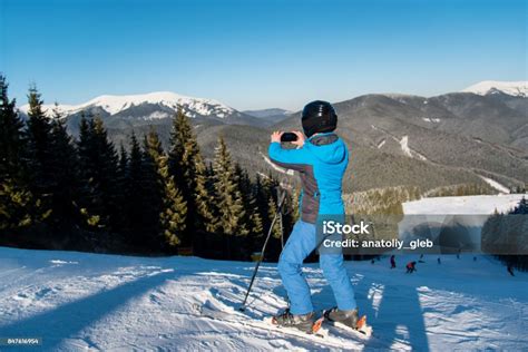 스키 리조트 기술 기억 연결 이동성 스포츠 레크리에이션에 산에서 멋진 겨울 경치의 사진을 찍은 그녀의 스마트 휴대 전화를 사용 하 여 여자 스키의 백 전체 길이 총 거리가