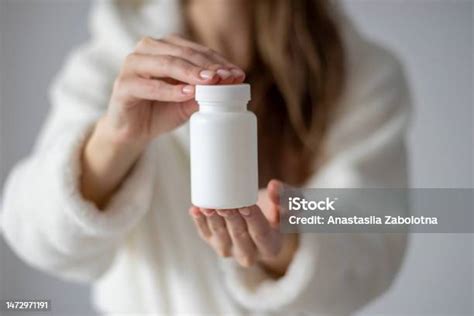 여자는 정제 알약 및 보충제를 위한 흰색 항아리를 들고 있습니다 모의 모형에 대한 스톡 사진 및 기타 이미지 모형 비타민 손 Istock