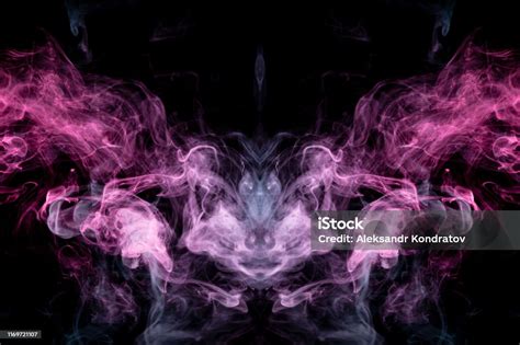 검은 색 고립 된 배경에 날개와 머리 얼굴과 눈의 모양에 공포의 형태로 다른 파란색 빨간색과 분홍색 색상의 연기 신비한 상징의