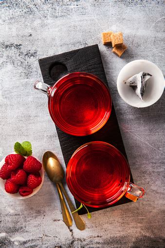 돌 테이블에 두 개의 투명 한 컵에 핫 라즈베리 티 신선한 딸기 지팡이 설탕 큐브 및 차 가방 0명에 대한 스톡 사진 및 기타 이미지 Istock