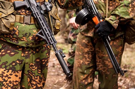 러시아 군인들은 삼림 지대 배경에서 무기를 들고 군용 위장 유니폼을 입은 러시아 군인들을 가까이에두고 있습니다 전쟁에 기관총을