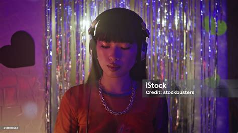 Young Asian Dj Mixing Tracks At Club Closeup Woman Controlling Music