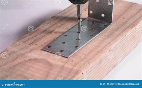 Household Chores Man Screwing Metal Corner To A Wooden Bar With A