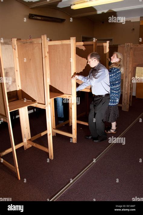 A Dramatically Lit Man And Woman Prepare Voting Booths In A Polling Station Stock Photo Alamy