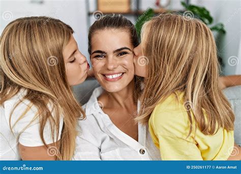 Mother And Daughters Kissing And Hugging Each Other At Home Stock Image