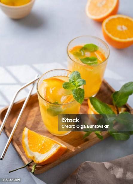 금속 튜브와 그림자가 있는 밝은 배경에 신선한 오렌지 민트 얼음이 있는 유리잔에 갓 짜낸 주스 아침 식사로 건강한 감귤 해독 음료 0명에 대한 스톡 사진 및 기타 이미지