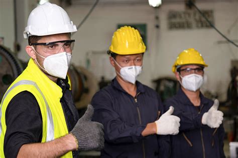 헬멧 안전 안경 금속 가공 제조 공장에서 엄지손가락을 들고 있는 마스크를 착용한 매니저와 작업자 직장 팀워크 및 산업 개념에서