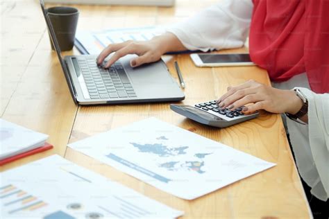 빨간 히잡을 쓴 젊은 아시아인이 노트북으로 서류 작업을 하고 있다 사진 Unsplash의 태국 이미지