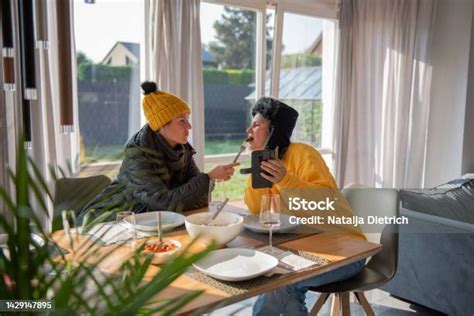 한 부부가 집에서 겨울 옷을 입고 식탁에 앉아 있고 춥고 얼어 붙고 에너지를 절약합니다 2명에 대한 스톡 사진 및 기타 이미지 Istock