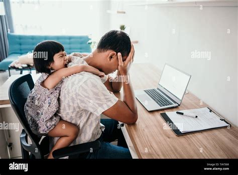 Portrait Of Father Feels Stressed When His Daughter Interrupts Work Stock Photo Alamy